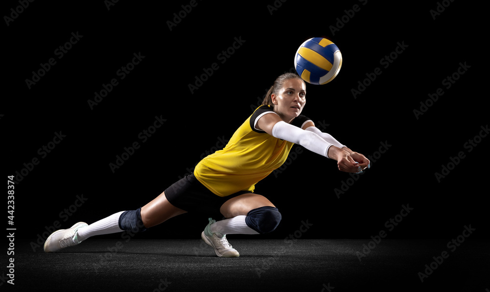 Female professional volleyball player with ball isolated on black ...