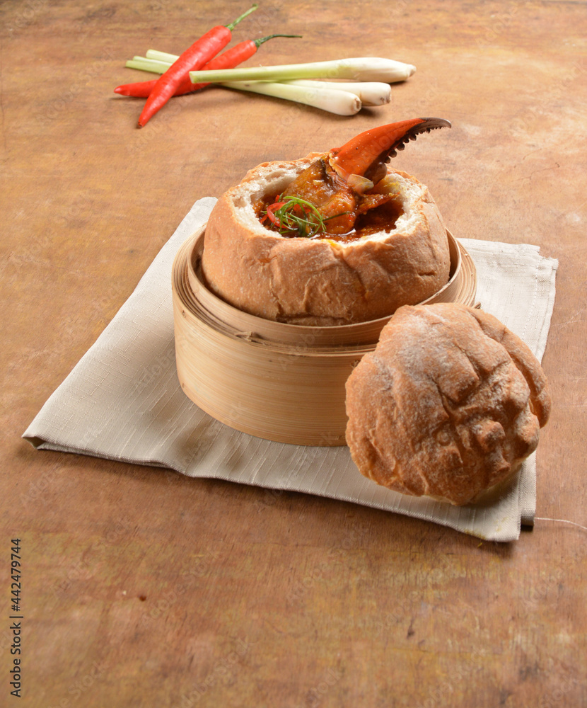 chef popular wok fried spicy chilli crab meat in round big baked bread ...