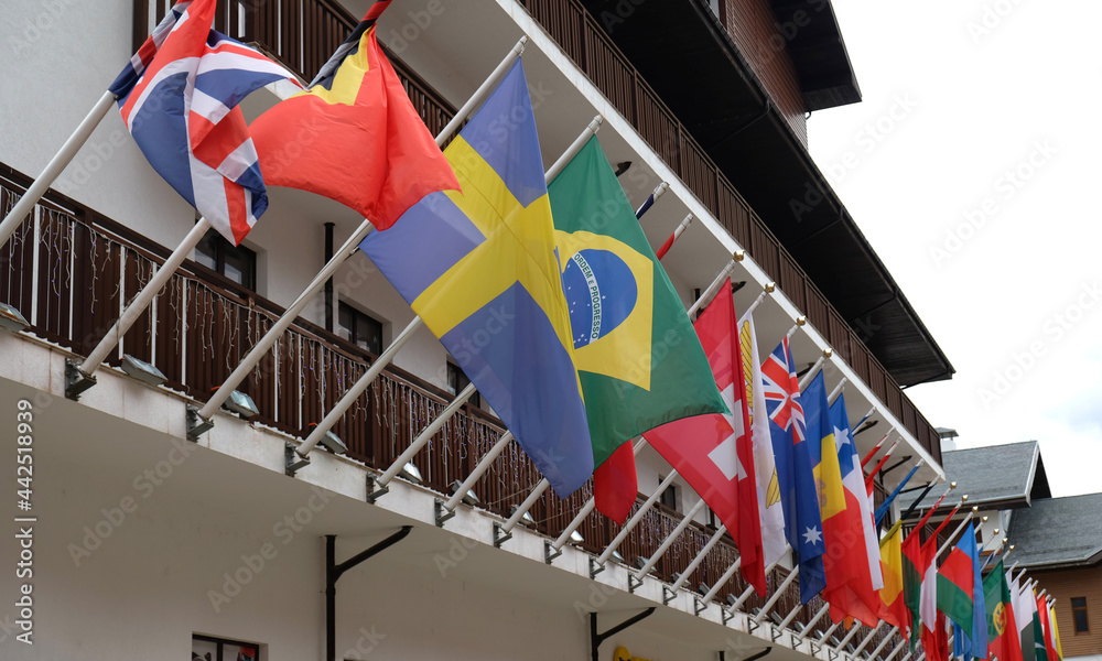Many national flags of different states hang and blowing on building ...
