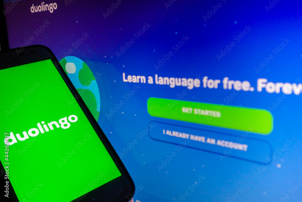 smartphone with Duolingo language app logo on screen. Blurred ...
