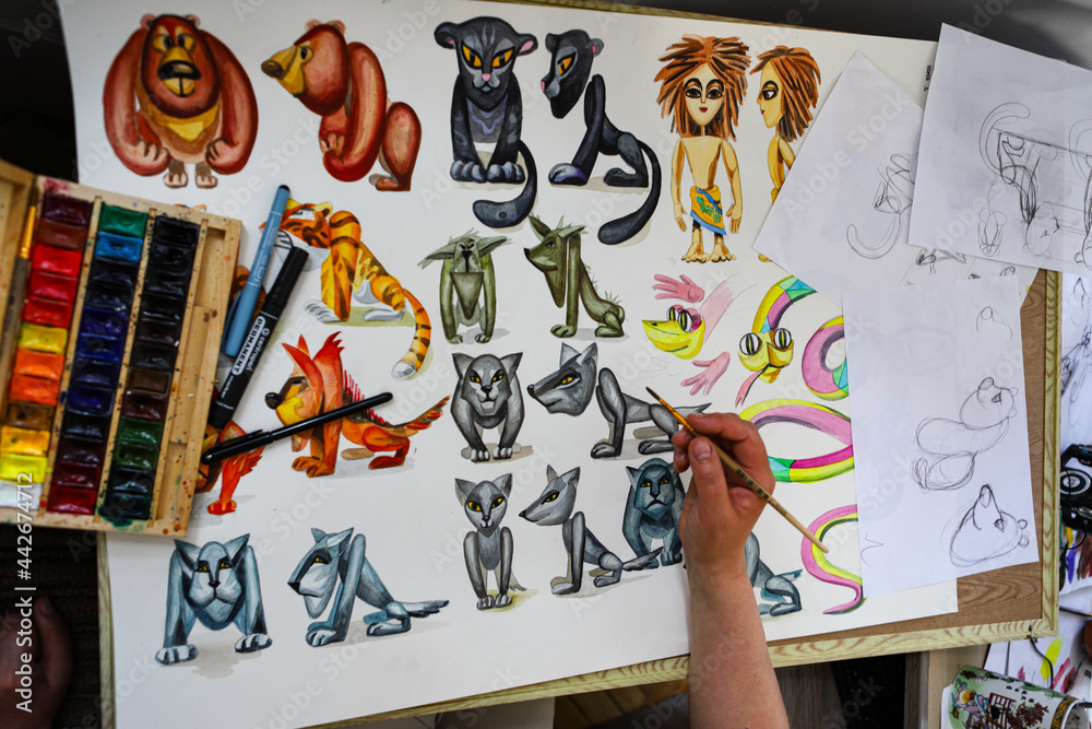 ภาพถ่าย Stock The animator draws with a pencil and draws characters ...
