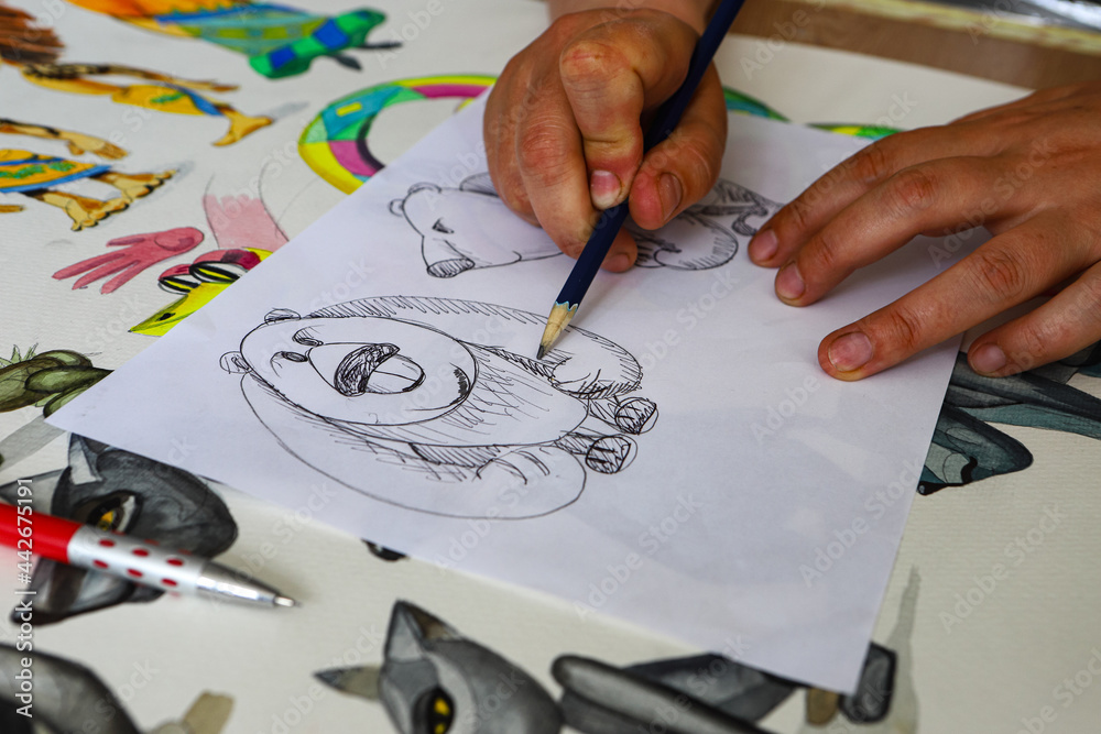 ภาพถ่าย Stock The animator draws with a pencil and draws characters ...