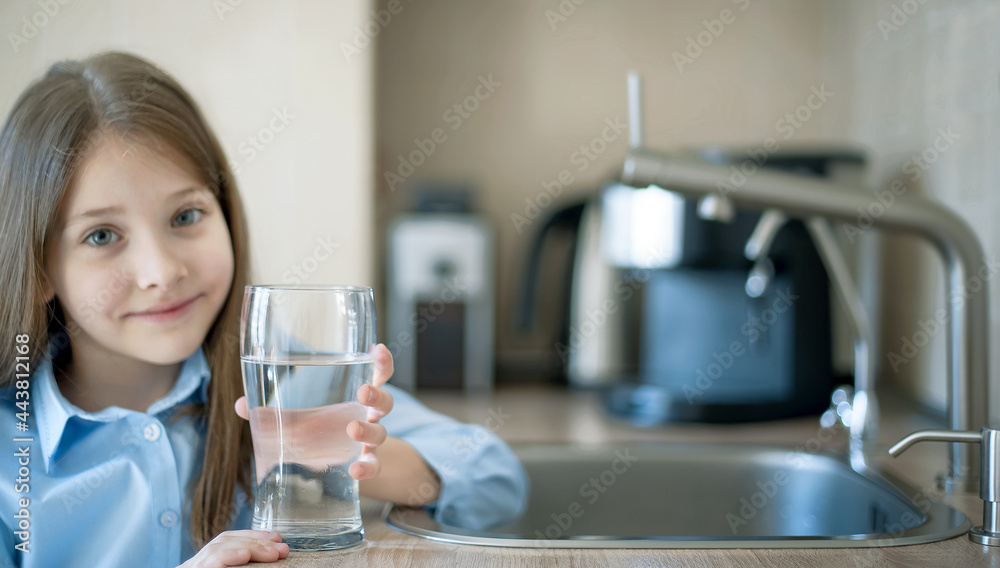 Little girl drinking from water tap or faucet in kitchen. Pouring fresh ...