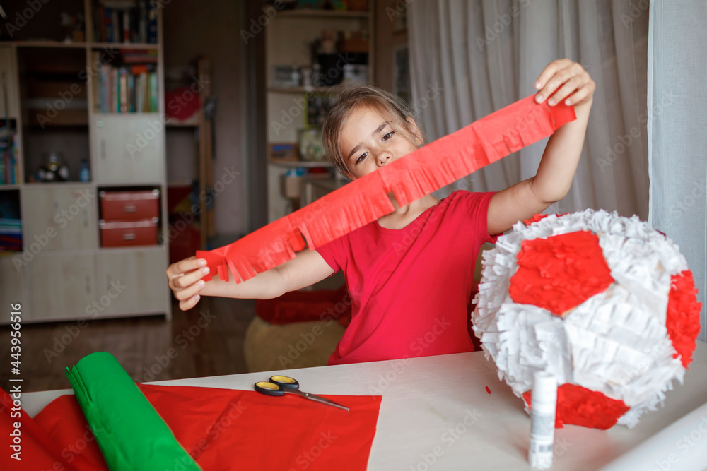 Preteen girl doing pinata with cardboard from used box and color crepe ...
