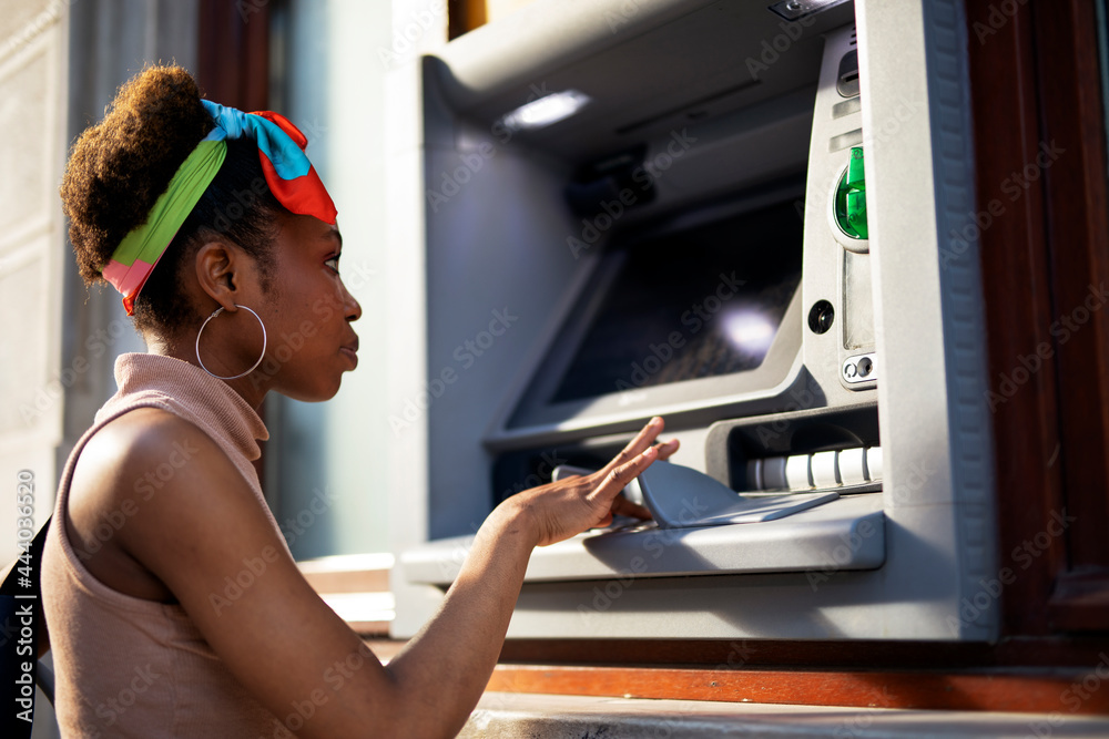 Beautiful african women using ATM machine. Attractive young woman ...