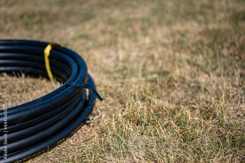 Coil of 1 inch irrigation tubing ready for new installation on top of ...