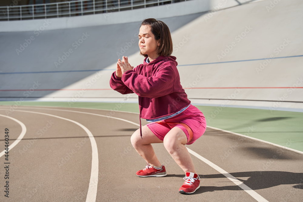 Stock-Foto „Midget girl with perfect body practicing squats with ...