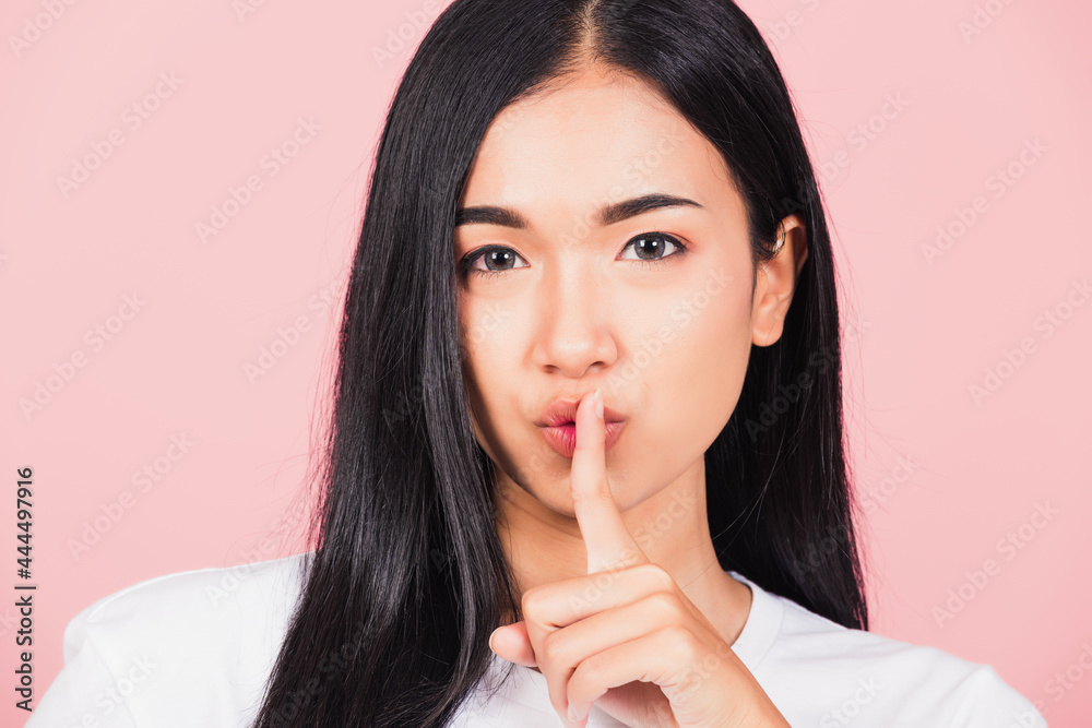 Asian happy portrait beautiful cute young woman smile stand making finger on lips mouth silent ...