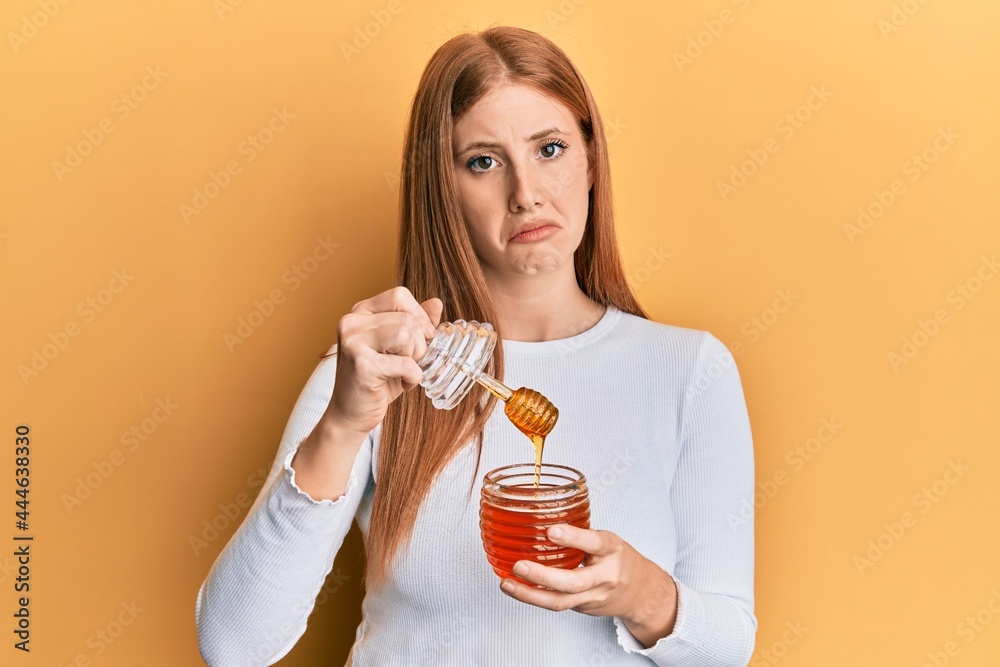 Young irish woman holding honey depressed and worry for distress ...