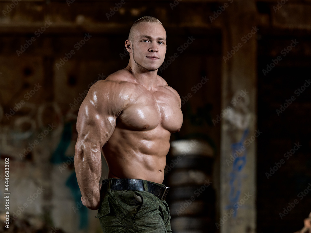 Fotografie Muscular bodybuilder with a naked torso in camouflage ...