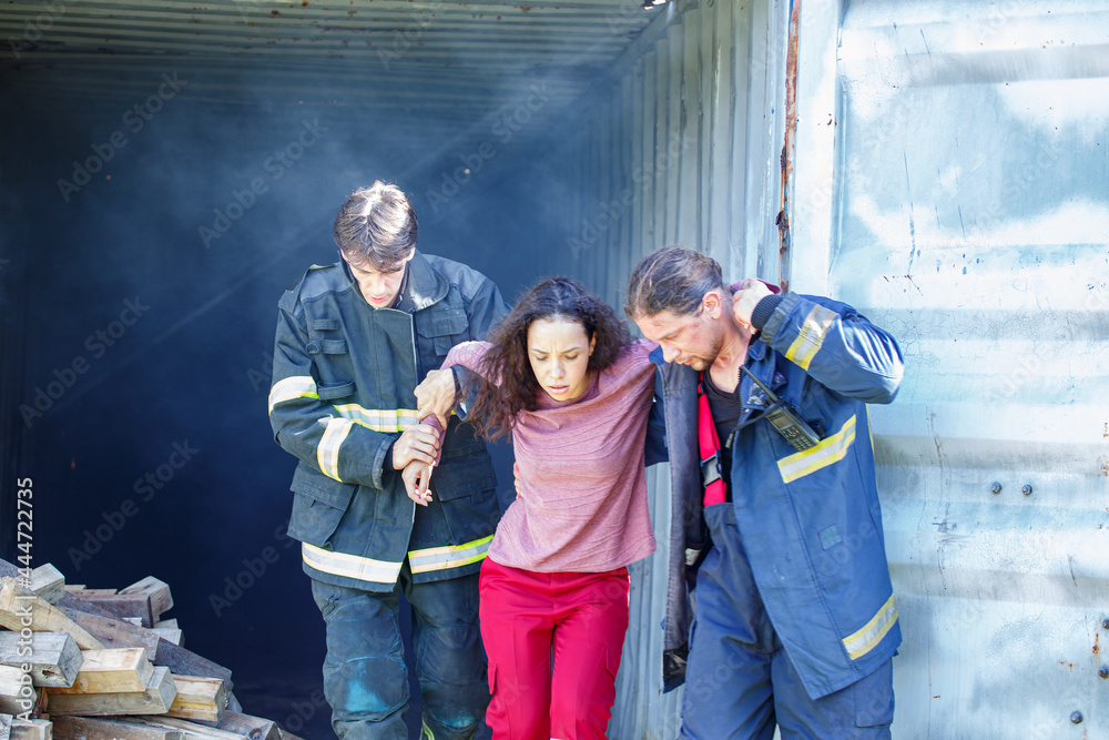 Brave firefighters rescuing injured woman from smoke-filled container ...