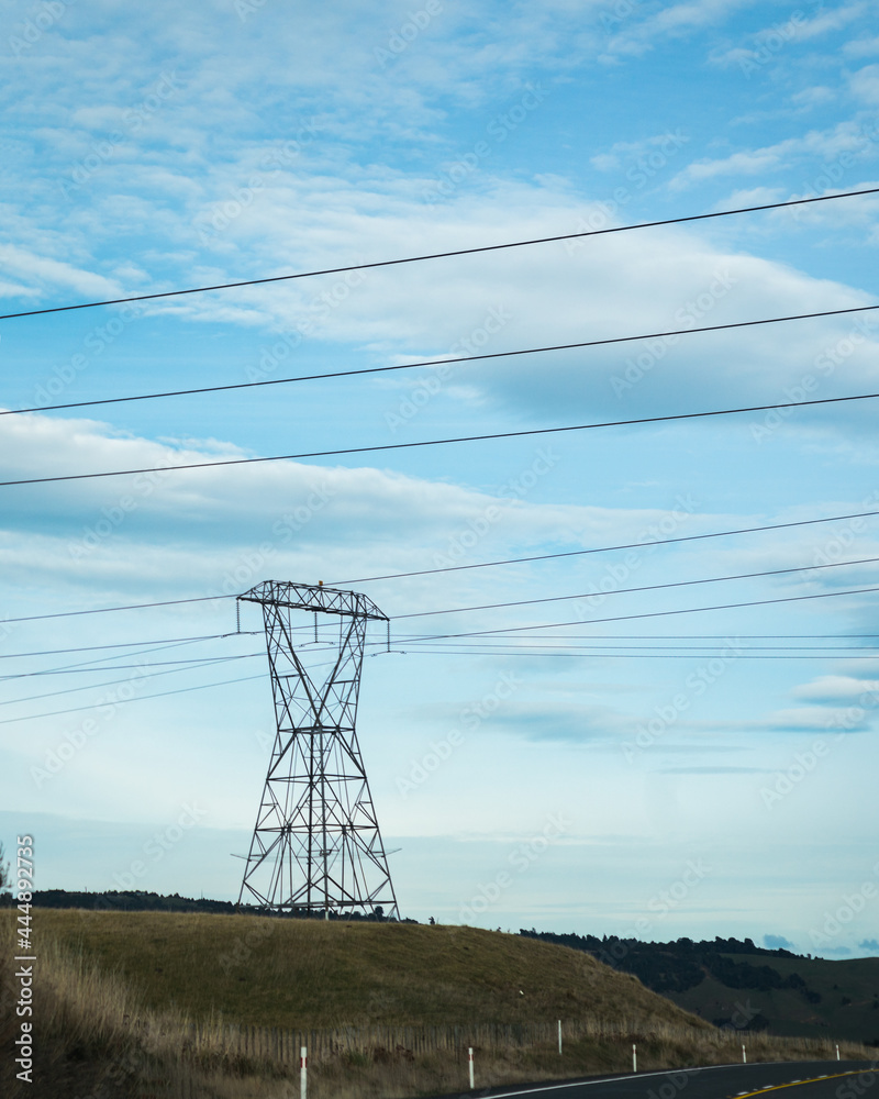 High voltage transmission towers and overhead powerlines against the ...