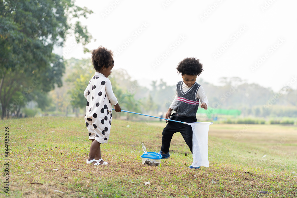Happy African American little boy and girl holding dustpan and ...