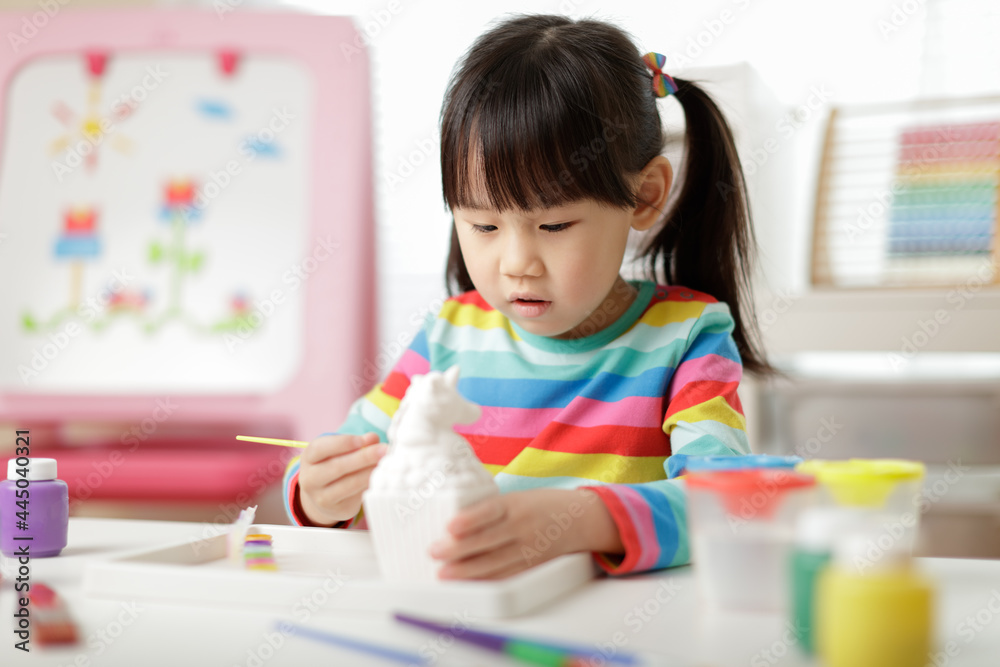 young girl painting money bank craft for homeschooling Stock Photo ...