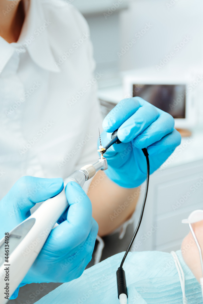 The dentist connects a sensor to the needle to remove the nerve in the ...