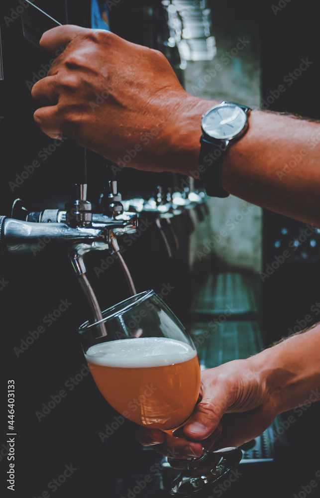 bartender hand at beer tap pouring a draught beer in glass serving in a restaurant or pub Stock ...