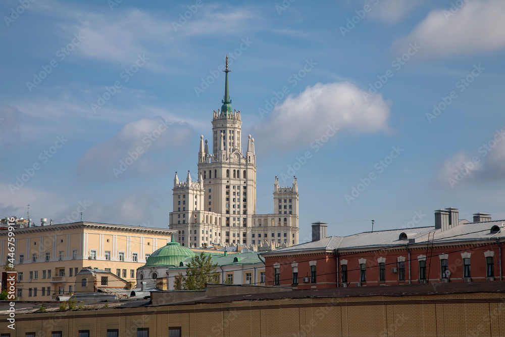 A beautiful old skyscraper with a spire can be seen behind the houses ...