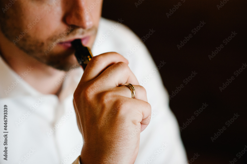 Man with vaping mod exhaling steam at studio background. Bearded guy ...
