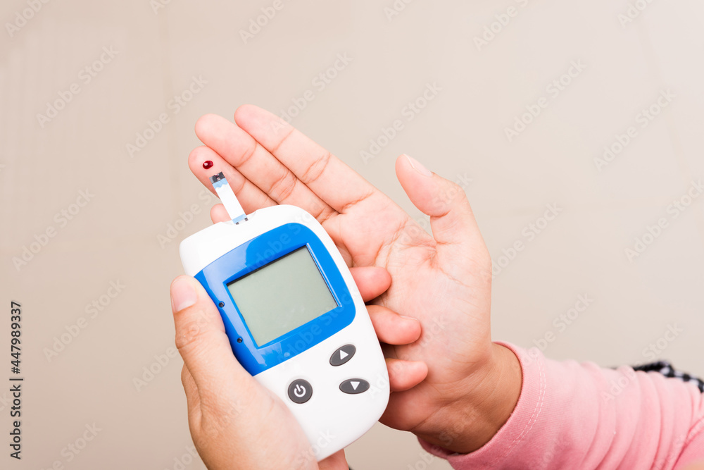 Closeup Hands woman measuring glucose test level check with blood on ...