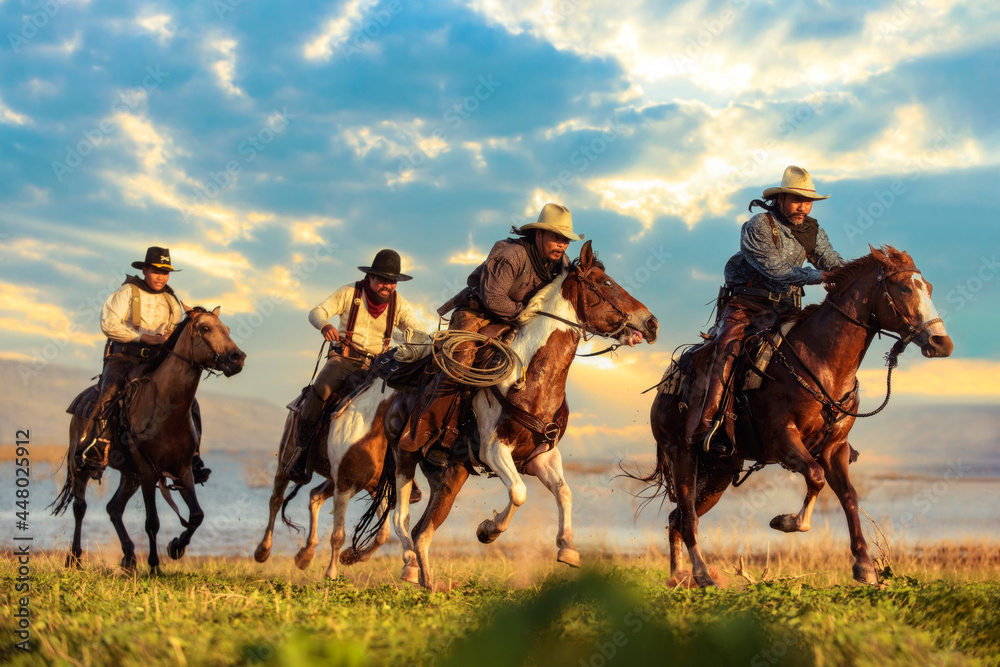ภาพถ่าย Stock Cowboy riding a horse carrying a gun | Adobe Stock