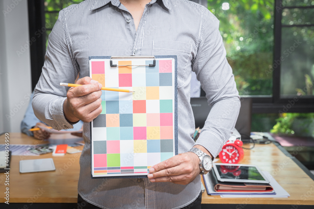 Young man holding and point to a color chart for home design. Graphic ...