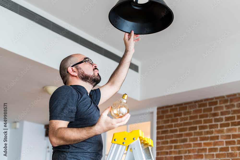 Man changing light bulb Stock Photo | Adobe Stock