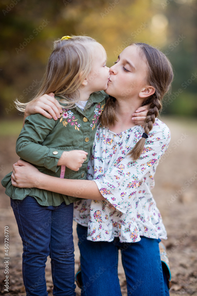 Portrait of two sisters kissing Stock Photo | Adobe Stock