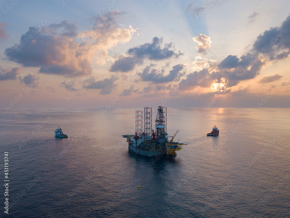 Offshore drilling rig (jack up rig) and tow vessels during the rig move operation in the middle ...