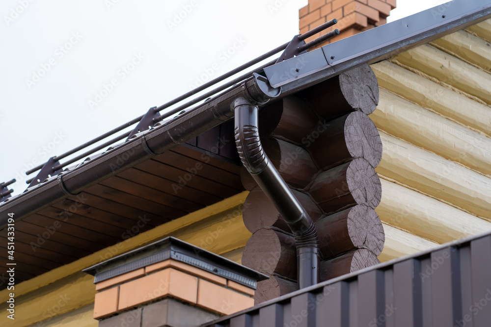 Roof gutter system on log house details close-up. Corner of house with ...