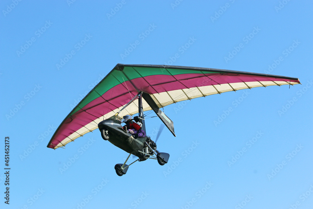 Ultralight airplane flying in a blue sky Stock Photo | Adobe Stock