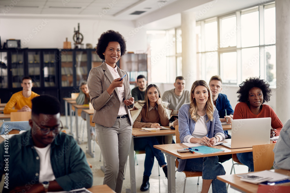 Happy African American professor teaches group of college students in ...