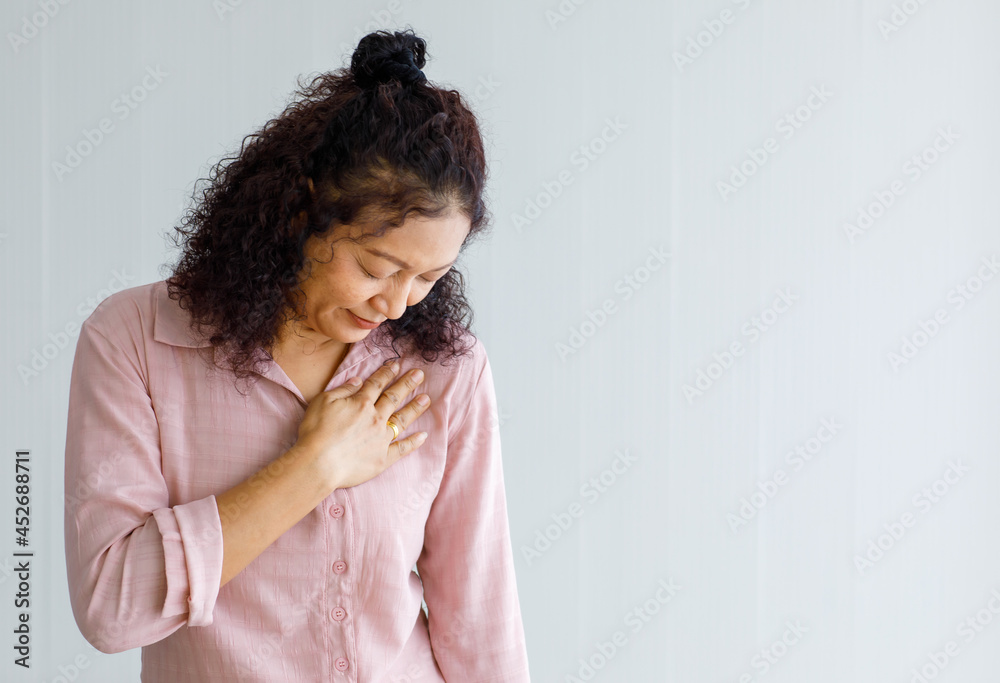 Adult female feels pain and use hand touch and hold on the chest ...