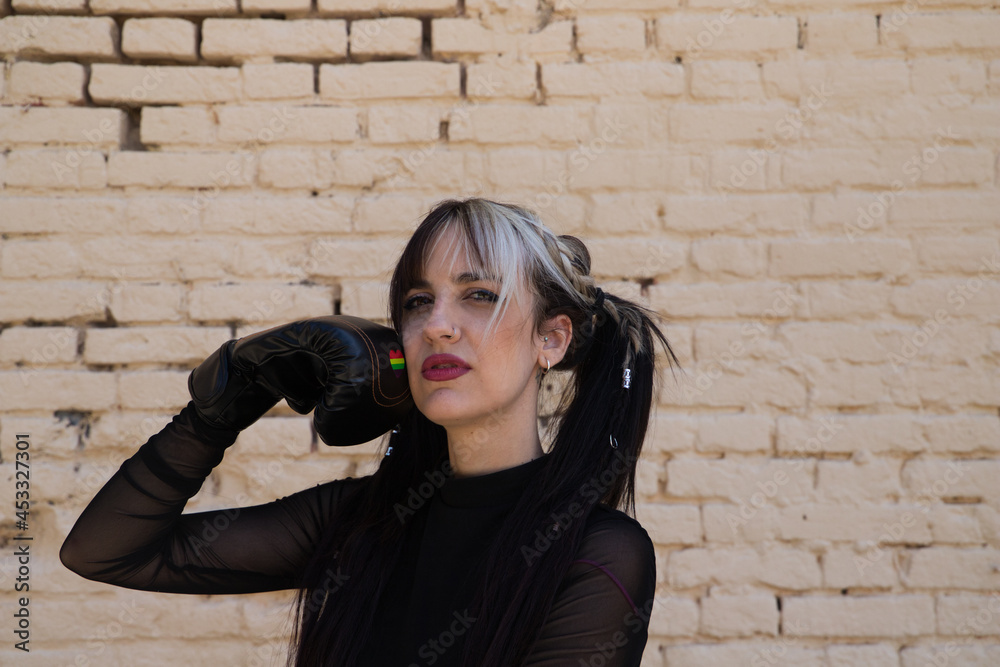 young and beautiful girl with a punky tendency. She is wearing boxing ...