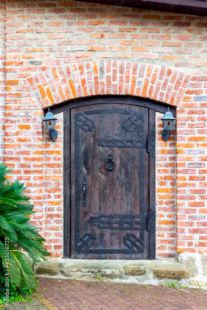 The facade of a vintage carved doorway, old wooden doors with a lock ...