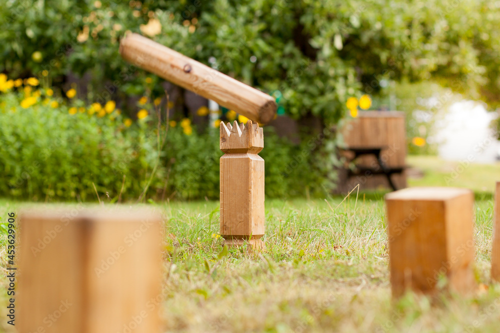 Wikingerschach (Kubb) aus Holz in Garten aufgestellt. Wooden Kubb sticks in garden. Wooden Kubb ...