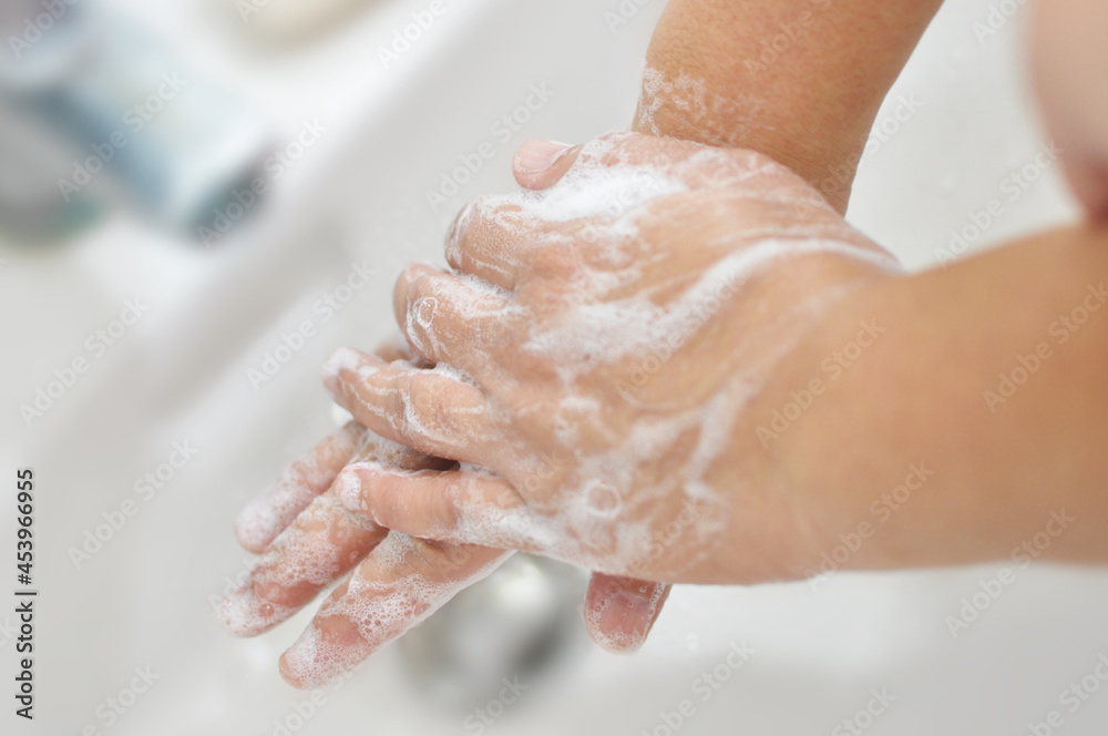 The hands of a woman girl with two hands. Washing hands sink with tap ...