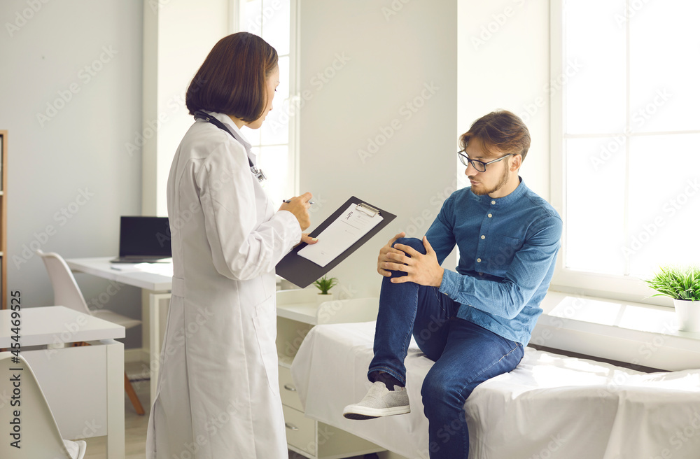 Patient sitting on hospital examination couch asks doctor to examine ...
