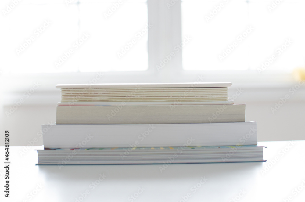 Books on the desk with white background, light colors, neutral colors ...