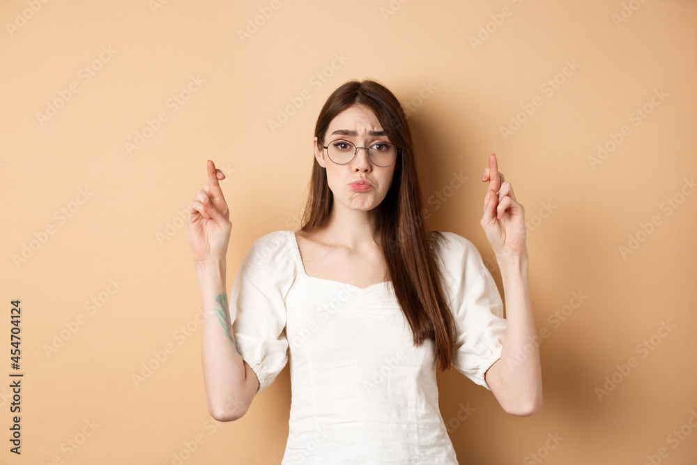 Cute hopeful girl making wish, pucker lips and begging, say please ...