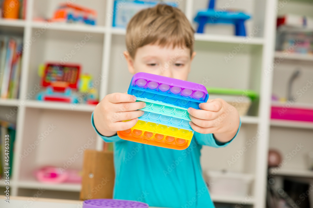 Child plays with sensory fidget toy Pop-it. Instrument for fine motoric ...