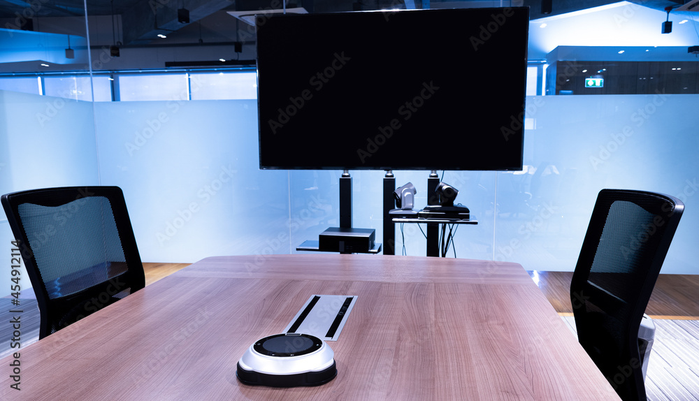 Wireless microphone portable on middle meeting table with blank screen ...