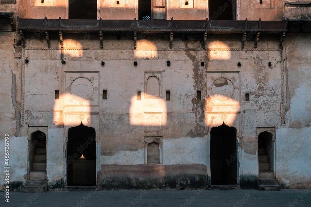 Windows of light on the shadows of the weathered walls of the ancient ...