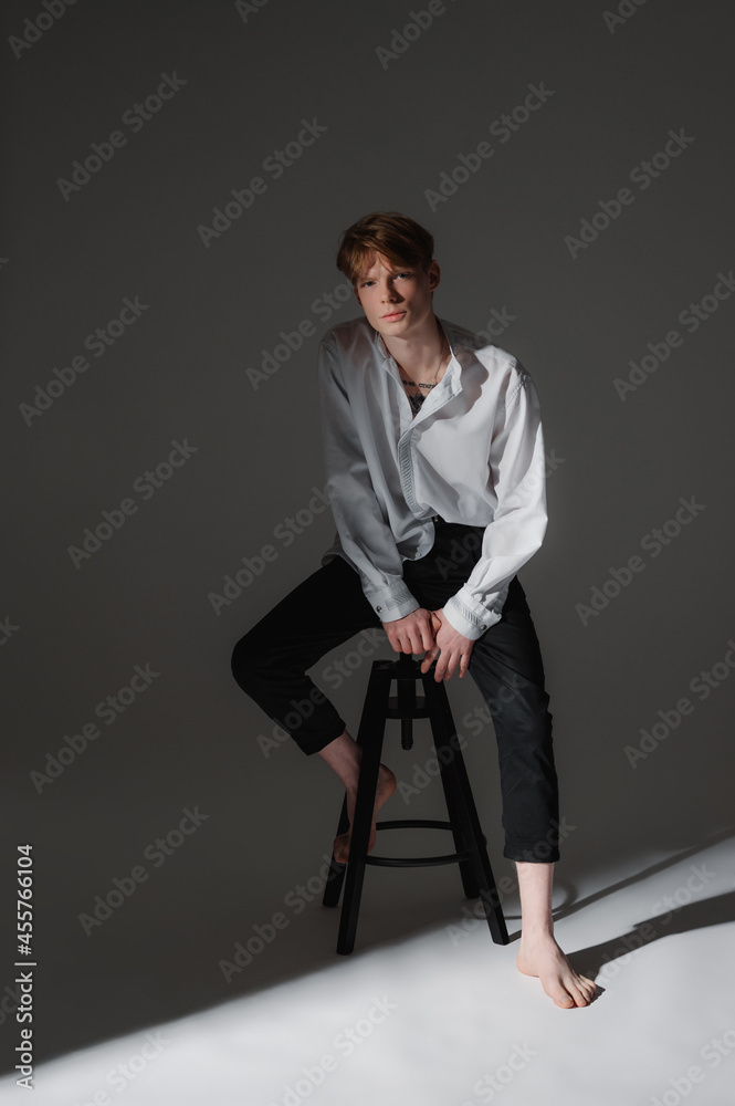 Barefoot young man on stool Stock Photo | Adobe Stock