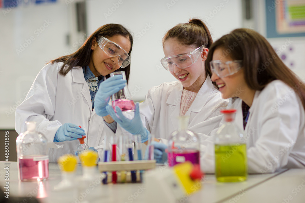 Girl students conducting scientific experiment in laboratory classroom ...