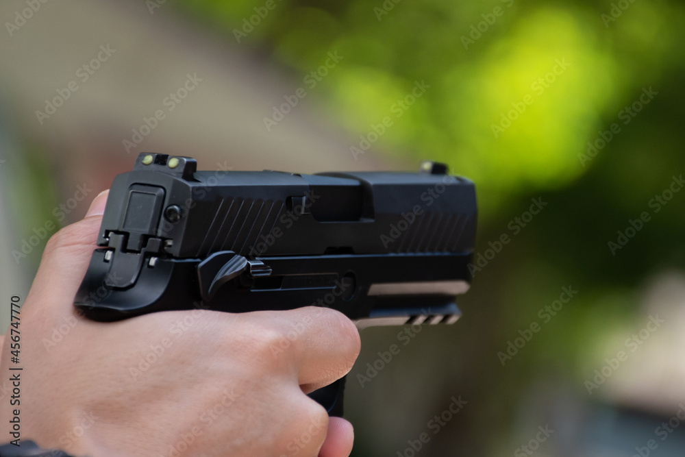 Foto de Stock Automatic black 9mm pistol holding in hands aming to the ...