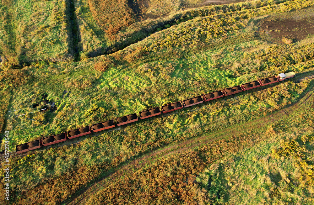 Train transports peat in freight wagons from peat extraction. Aerial ...