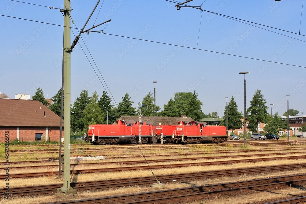 View of red locomotive and multiple train tracks from platform at ...