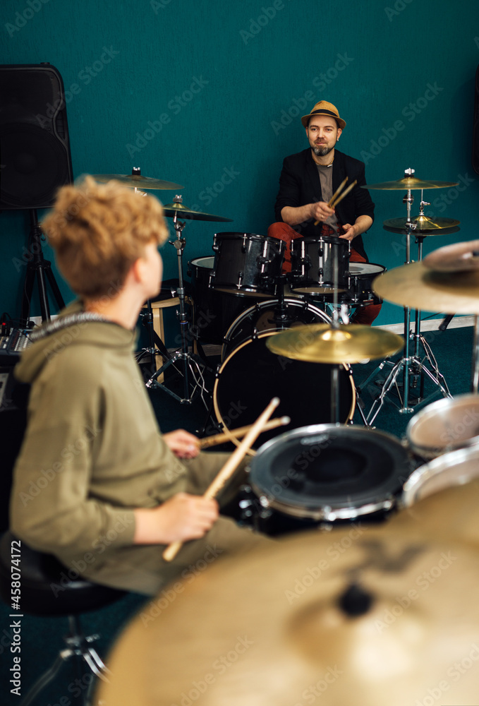 The teacher shows the boy how to play the drums correctly. Lesson at ...