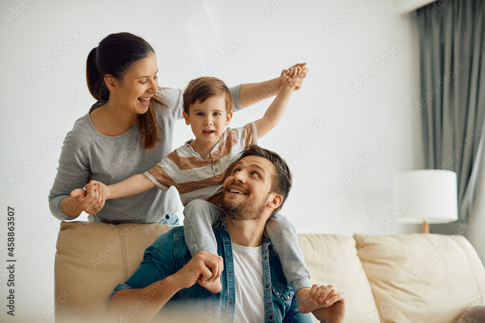 Happy parents have fun while playing with their small son at home ...
