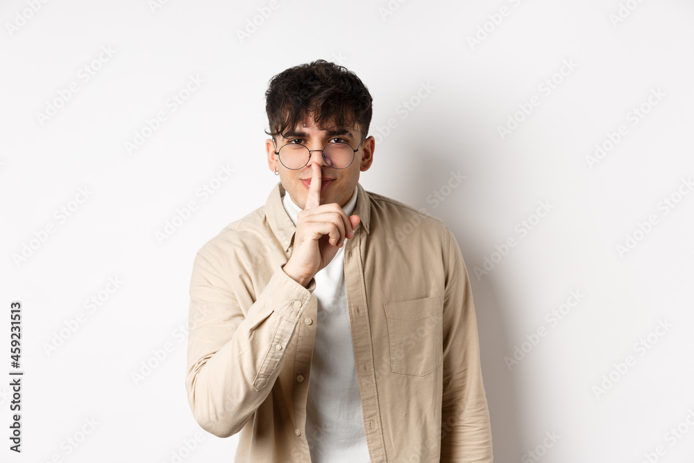 Cheerful handsome man in glasses share a secret, making surprise, lean ...